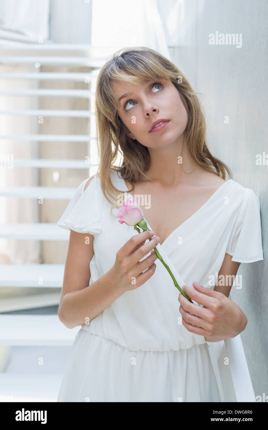 Thoughtful beautiful woman with a flower Stock Photo - Alamy