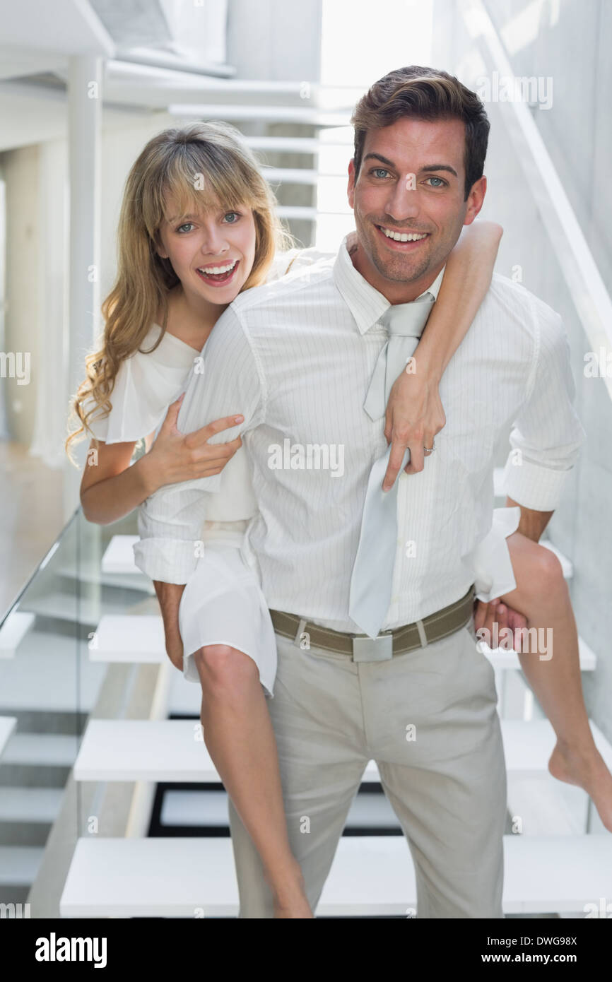 Smiling young man carrying woman Stock Photo - Alamy