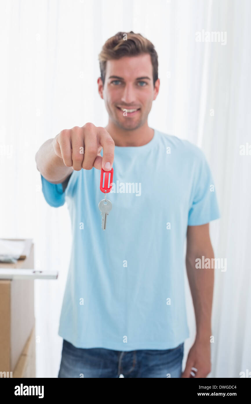 Young man holding out new house key Stock Photo - Alamy