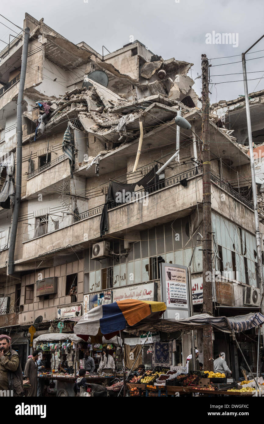 Aleppo, Syria. 2nd Apr, 2013. Civilians walking by a building destroyed ...