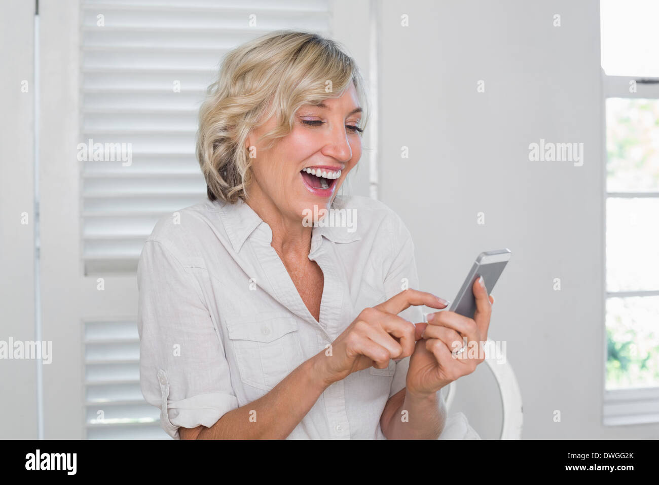 Cheerful mature woman text messaging Stock Photo - Alamy