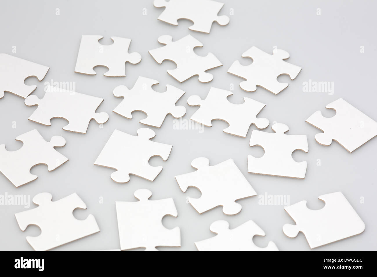Blank jigsaw puzzle pieces placed randomly at white table Stock Photo ...