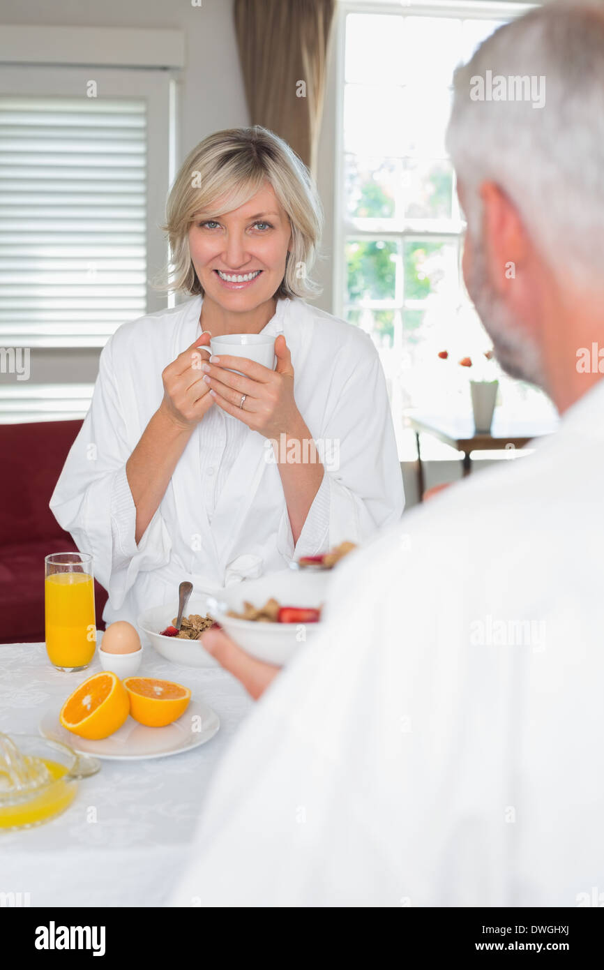 Smiling mature woman having breakfast with cropped man Stock Photo - Alamy
