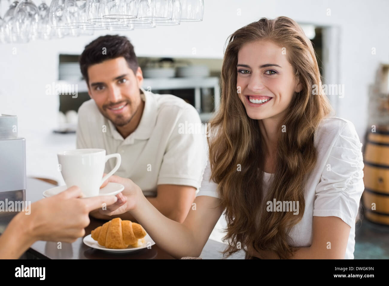 Hand giving coffee to a couple at coffee shop Stock Photo - Alamy
