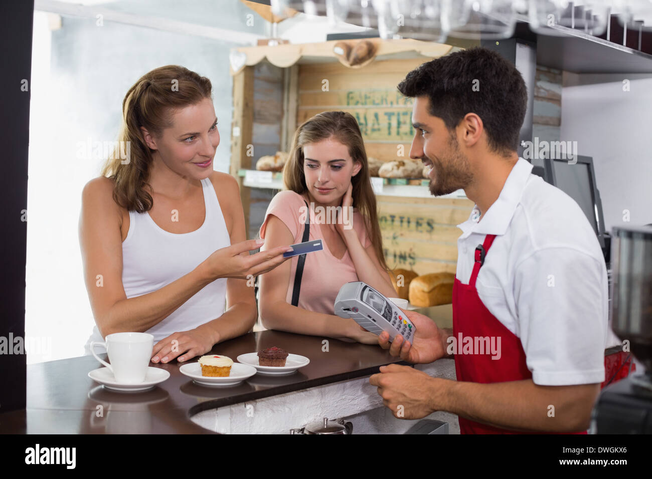 Friends paying bill at coffee shop using card bill Stock Photo - Alamy