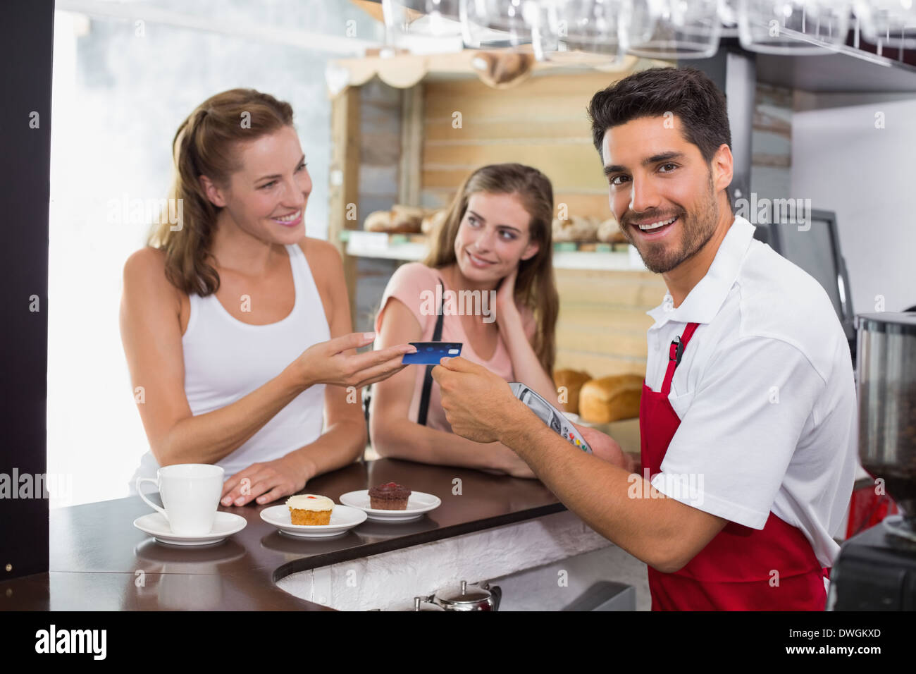 Friends paying bill at coffee shop using card bill Stock Photo - Alamy