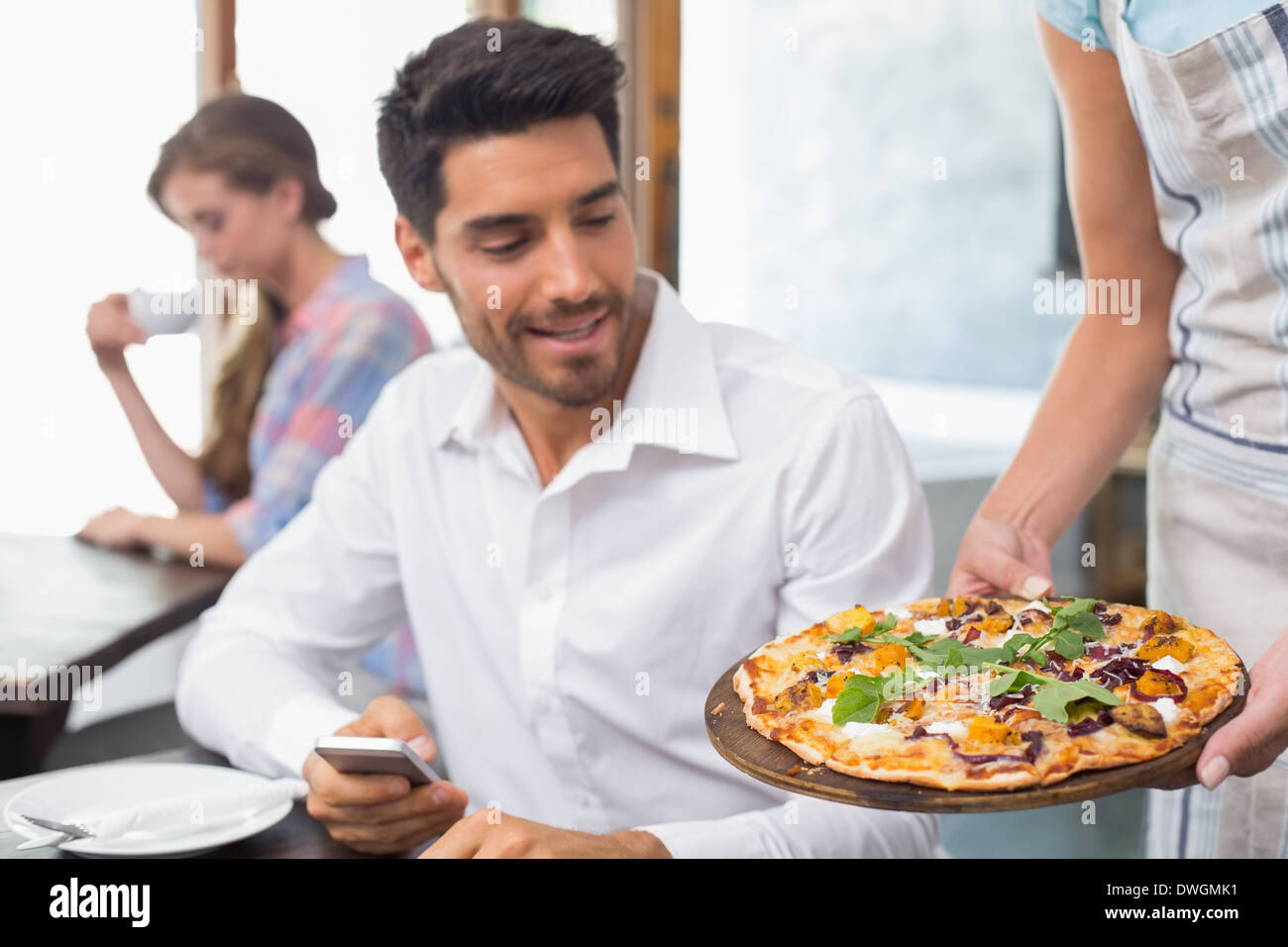Waitress giving pizza to man at coffee shop Stock Photo - Alamy