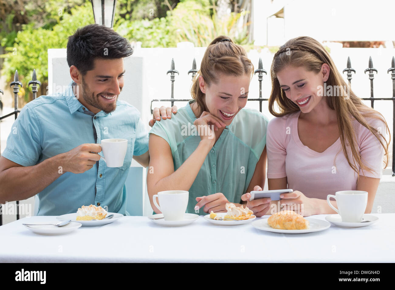 Happy friends reading text message in caf├⌐ Stock Photo - Alamy