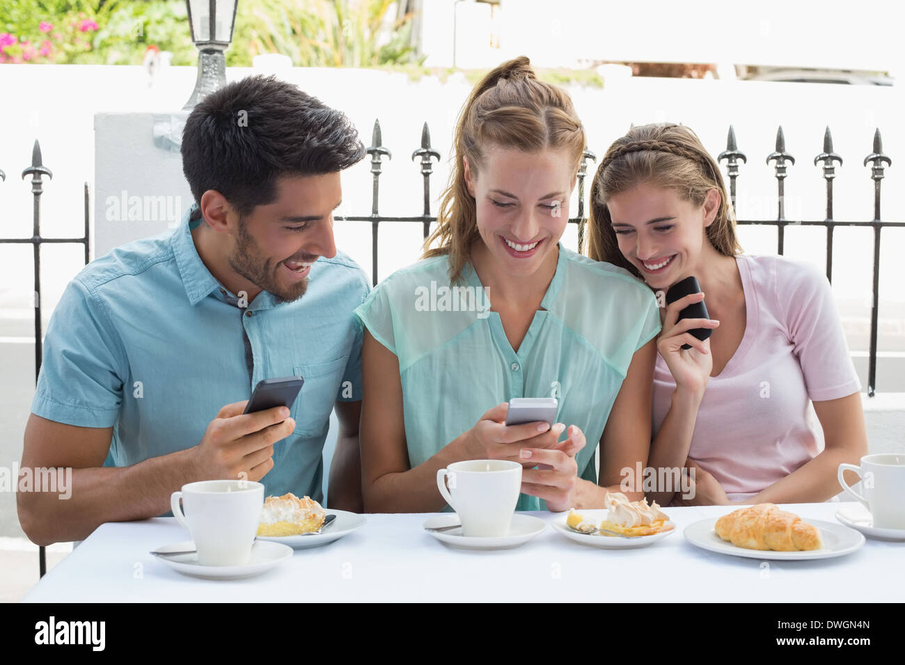 Happy friends reading text message in caf├⌐ Stock Photo - Alamy