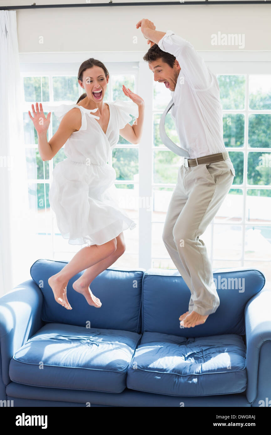 Young woman jumping on sofa hi-res stock photography and images - Alamy