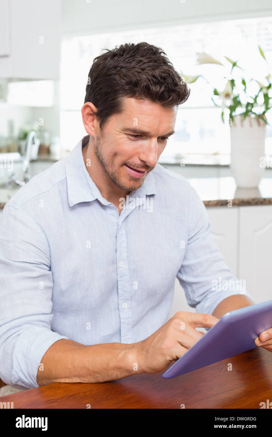 Concentrated relaxed man using digital tablet in kitchen Stock Photo ...