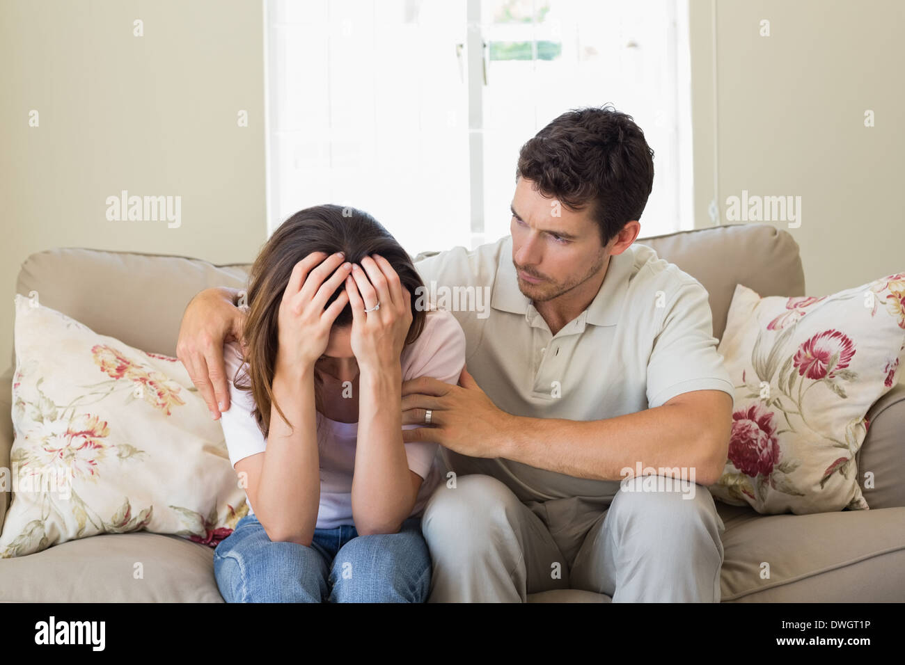 Man consoling a sad woman in living room Stock Photo - Alamy