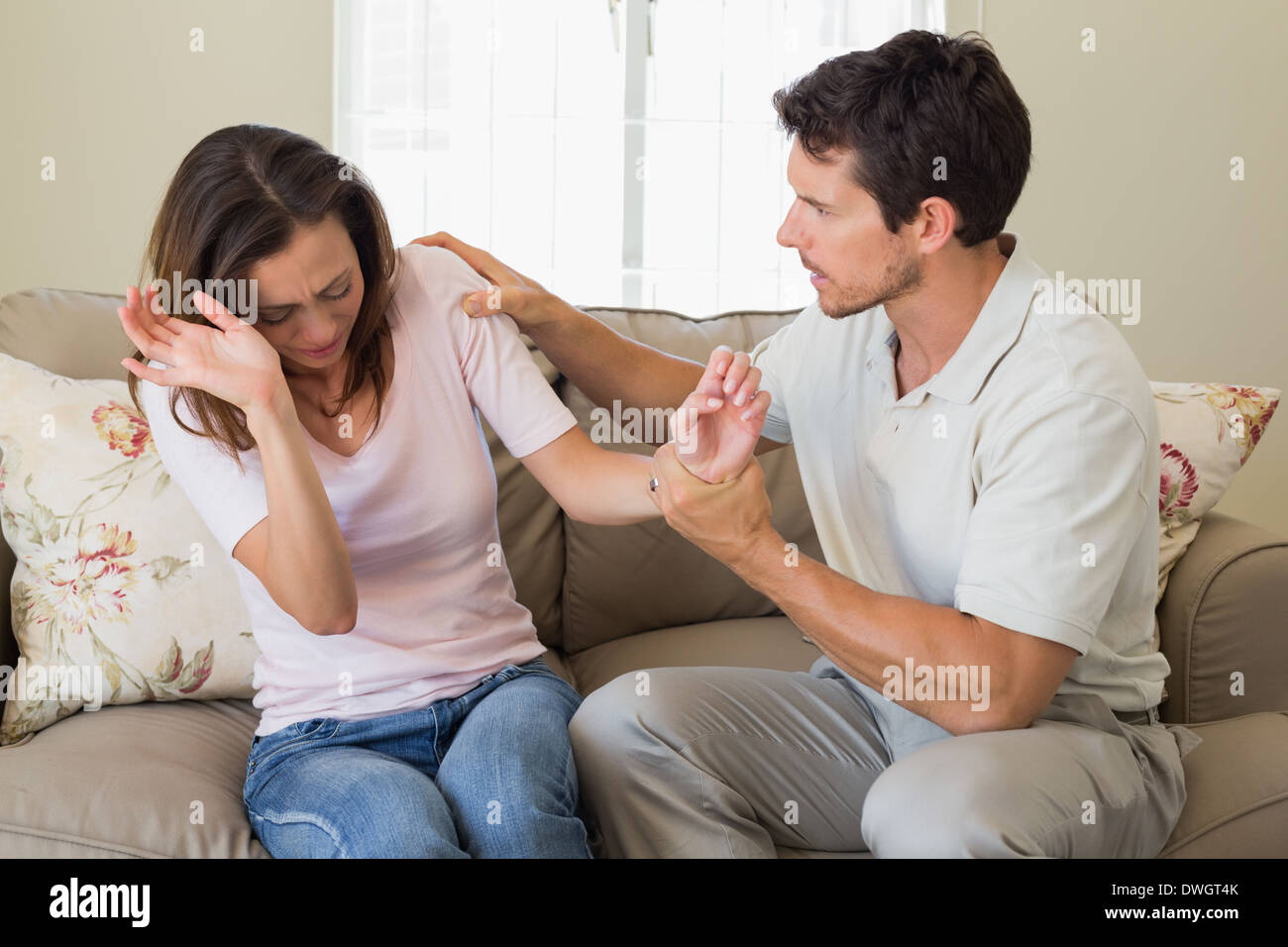 Man consoling a sad woman in living room Stock Photo - Alamy