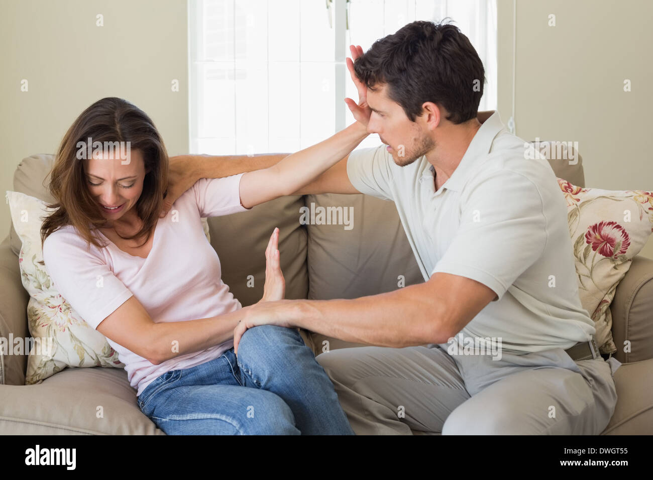 Man consoling a sad woman in living room Stock Photo - Alamy