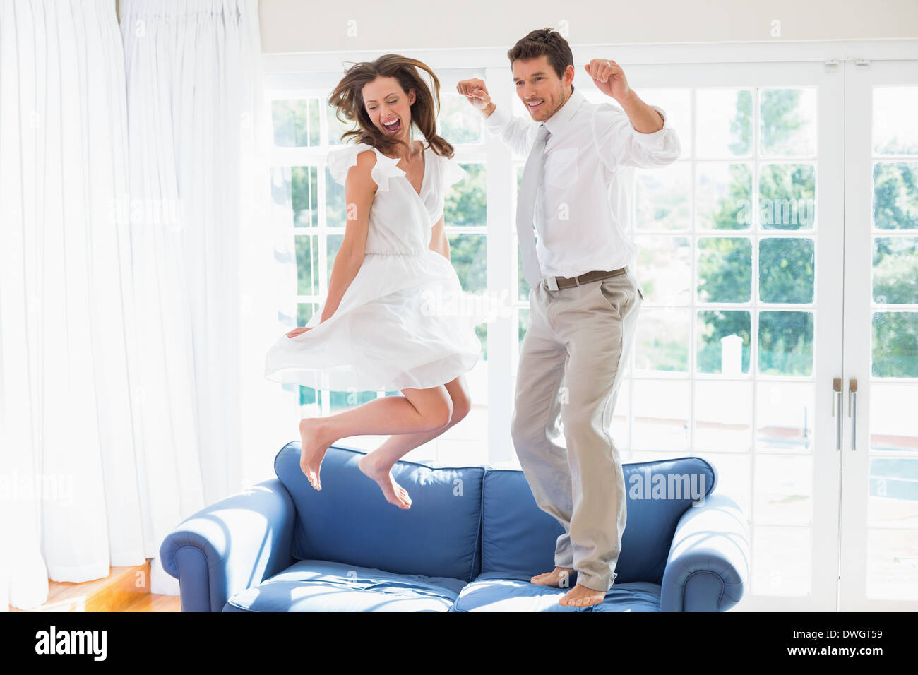 Young woman jumping on sofa hi-res stock photography and images - Alamy