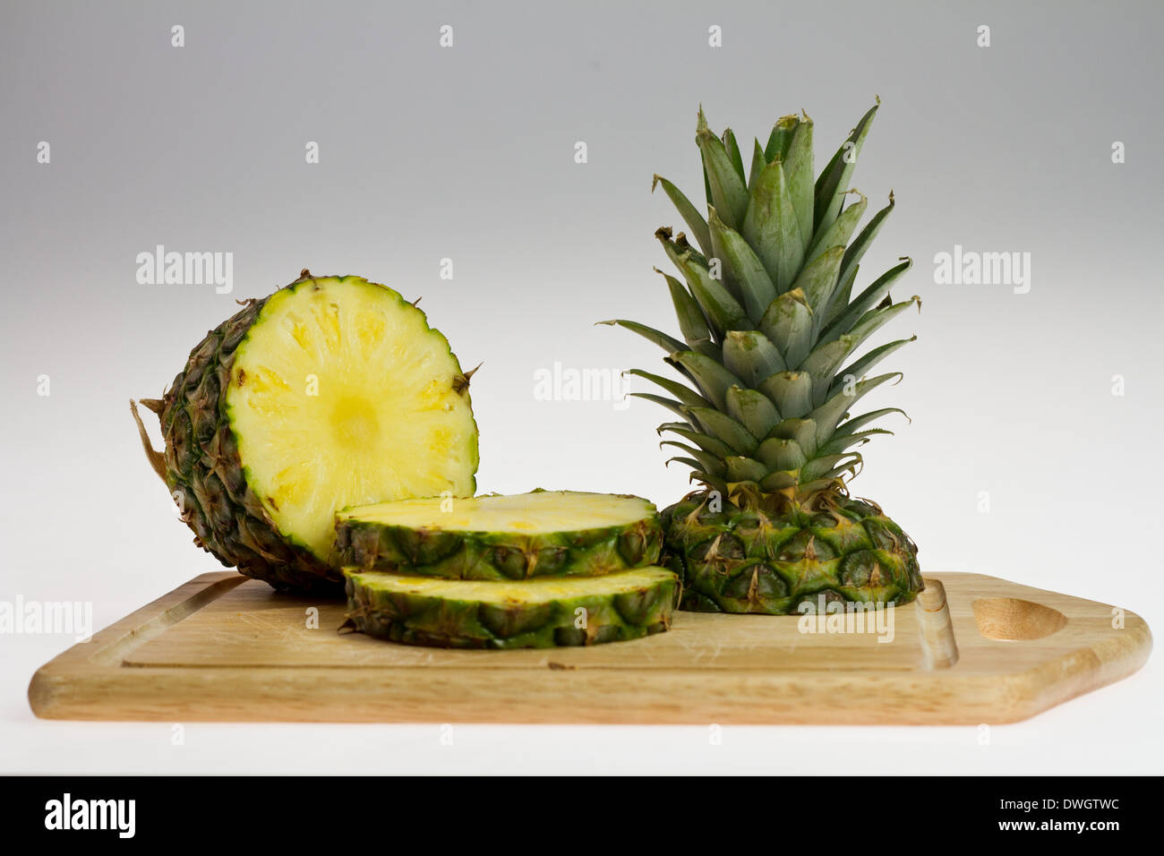 A Pineapple sliced up on a chopping board Stock Photo - Alamy