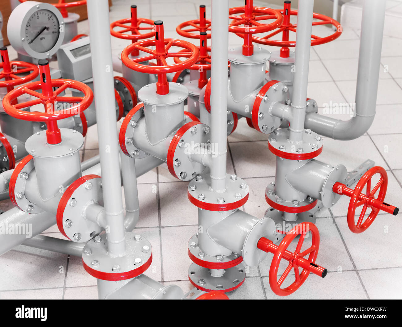 Group of red industrial valves on gray pipelines Stock Photo - Alamy