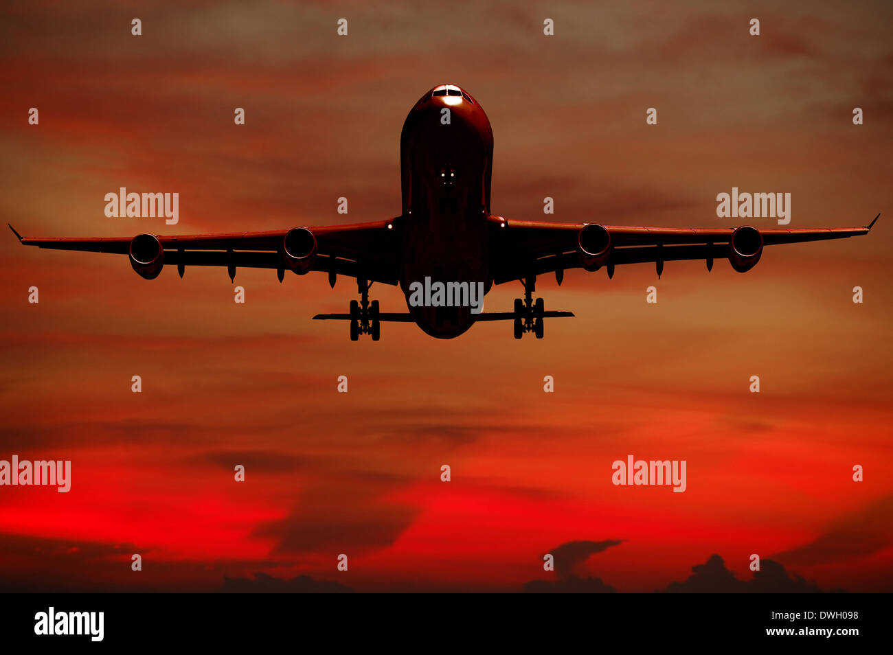 Plane is flying while the sun is setting Stock Photo - Alamy