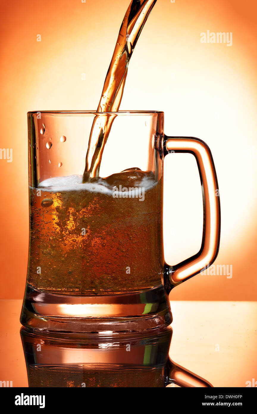 Pouring beer into mug over orange background Stock Photo - Alamy Pouring beer into mug over orange background Stock Photo - Alamy