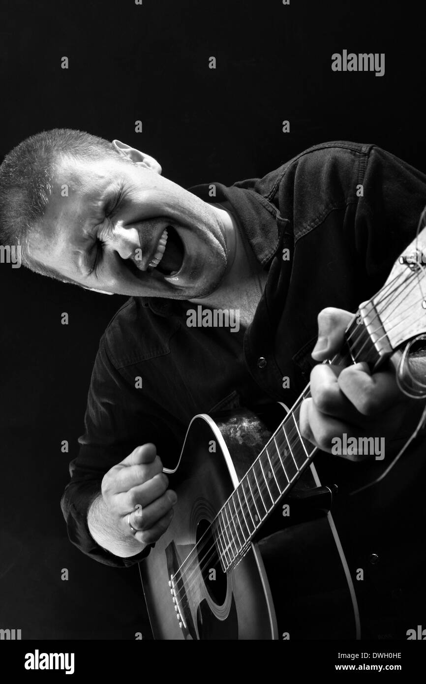 Man playing acoustic guitar at rock concert Stock Photo - Alamy