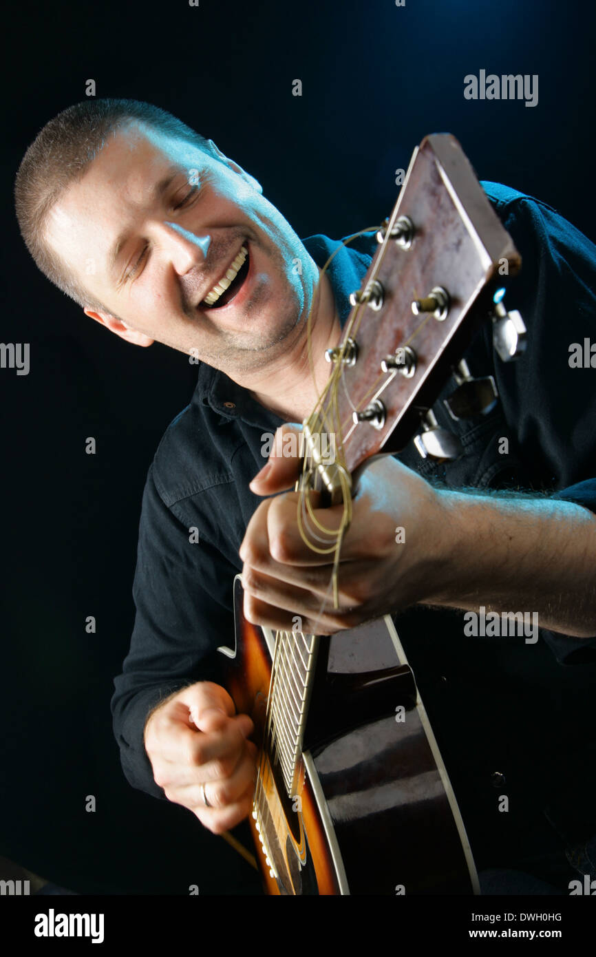 Man playing acoustic guitar at rock concert Stock Photo - Alamy