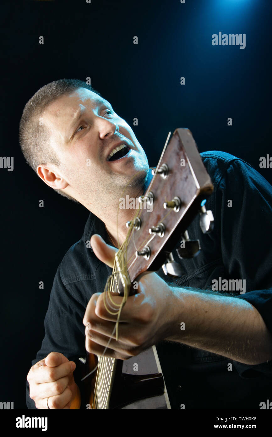 Man playing acoustic guitar at rock concert Stock Photo - Alamy