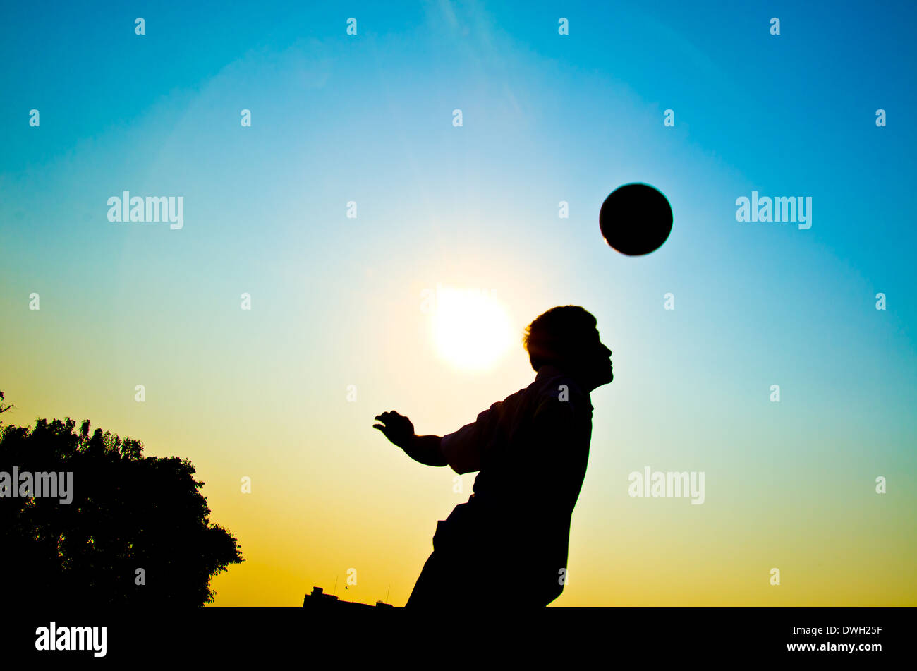 silhouette of man heading football for goal Stock Photo - Alamy