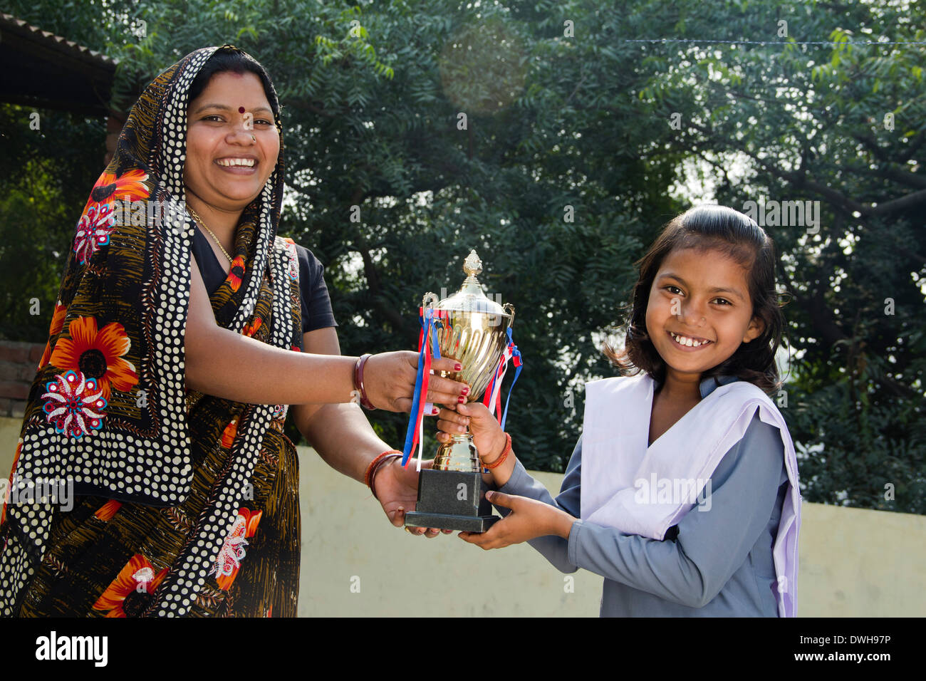 Indian woman giving trophy to kids Stock Photo - Alamy