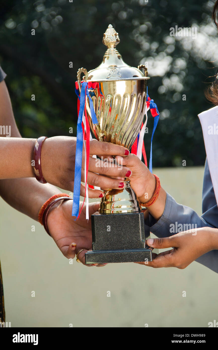 Indian woman giving trophy to kids Stock Photo - Alamy