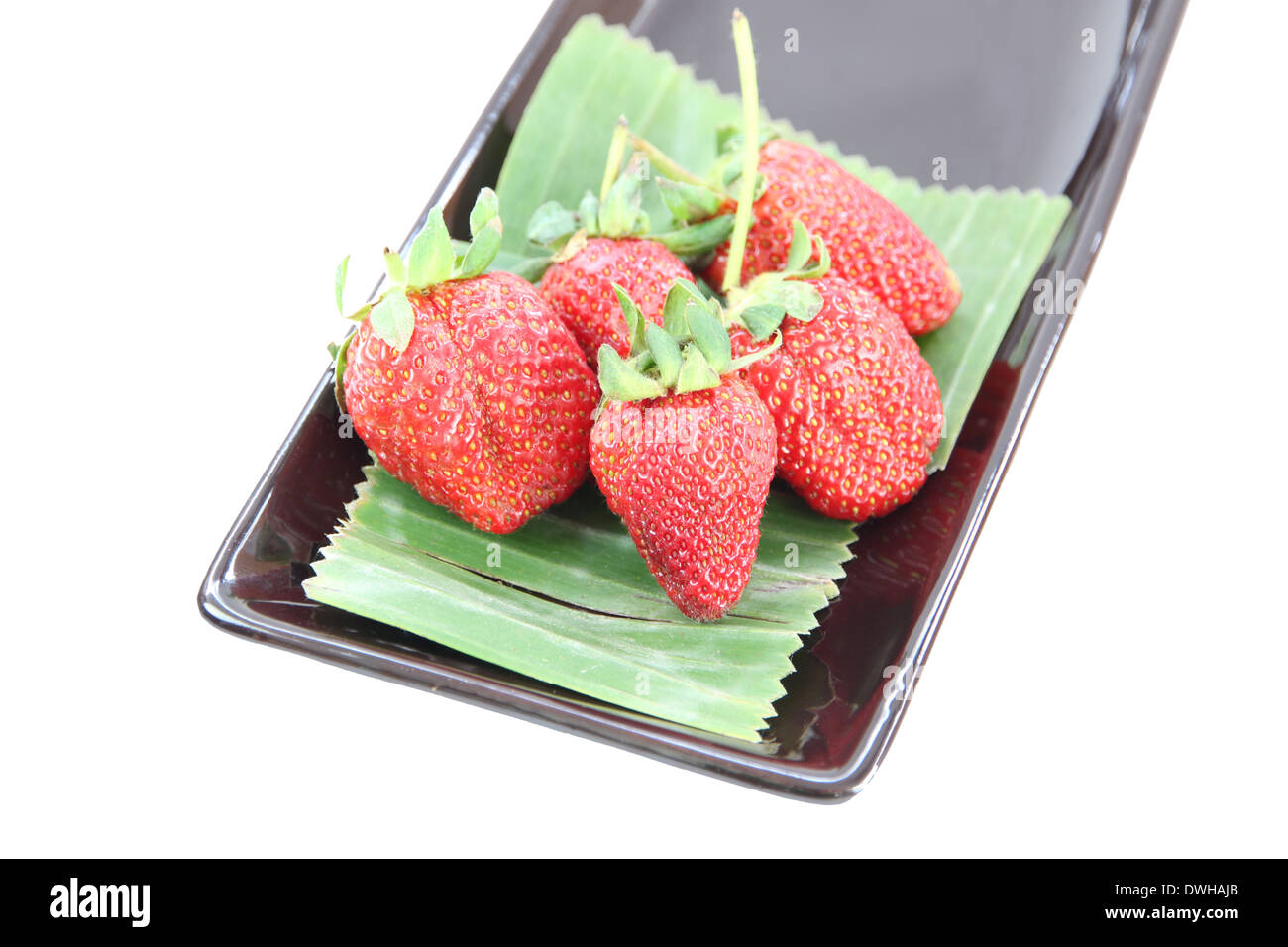 Four Strawberry in black dish on white background Stock Photo - Alamy