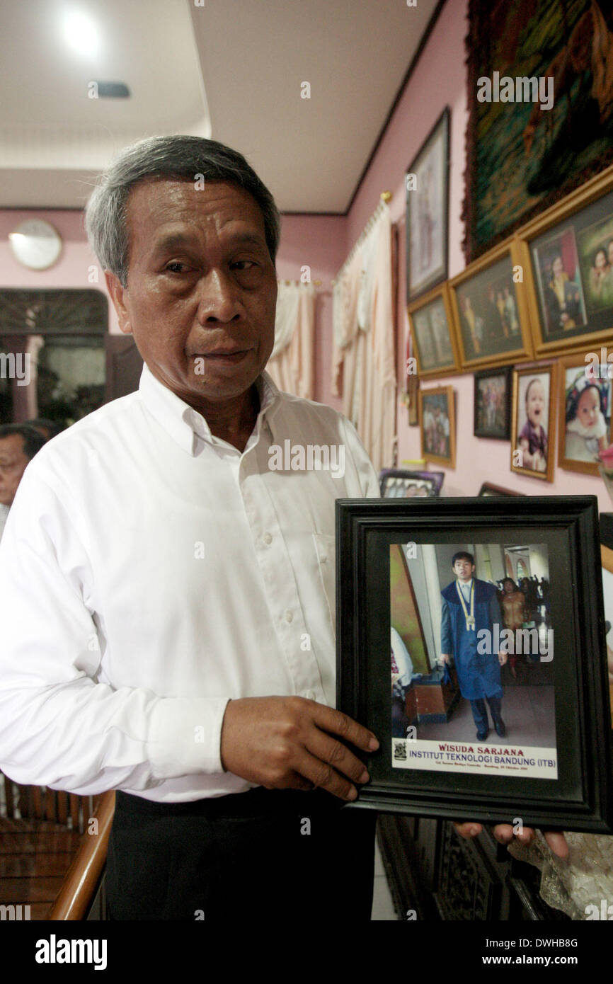 (140309) -- MEDAN, March. 9, 2014 (Xinhua) -- A family member shows a photo of Firman Chandra ...