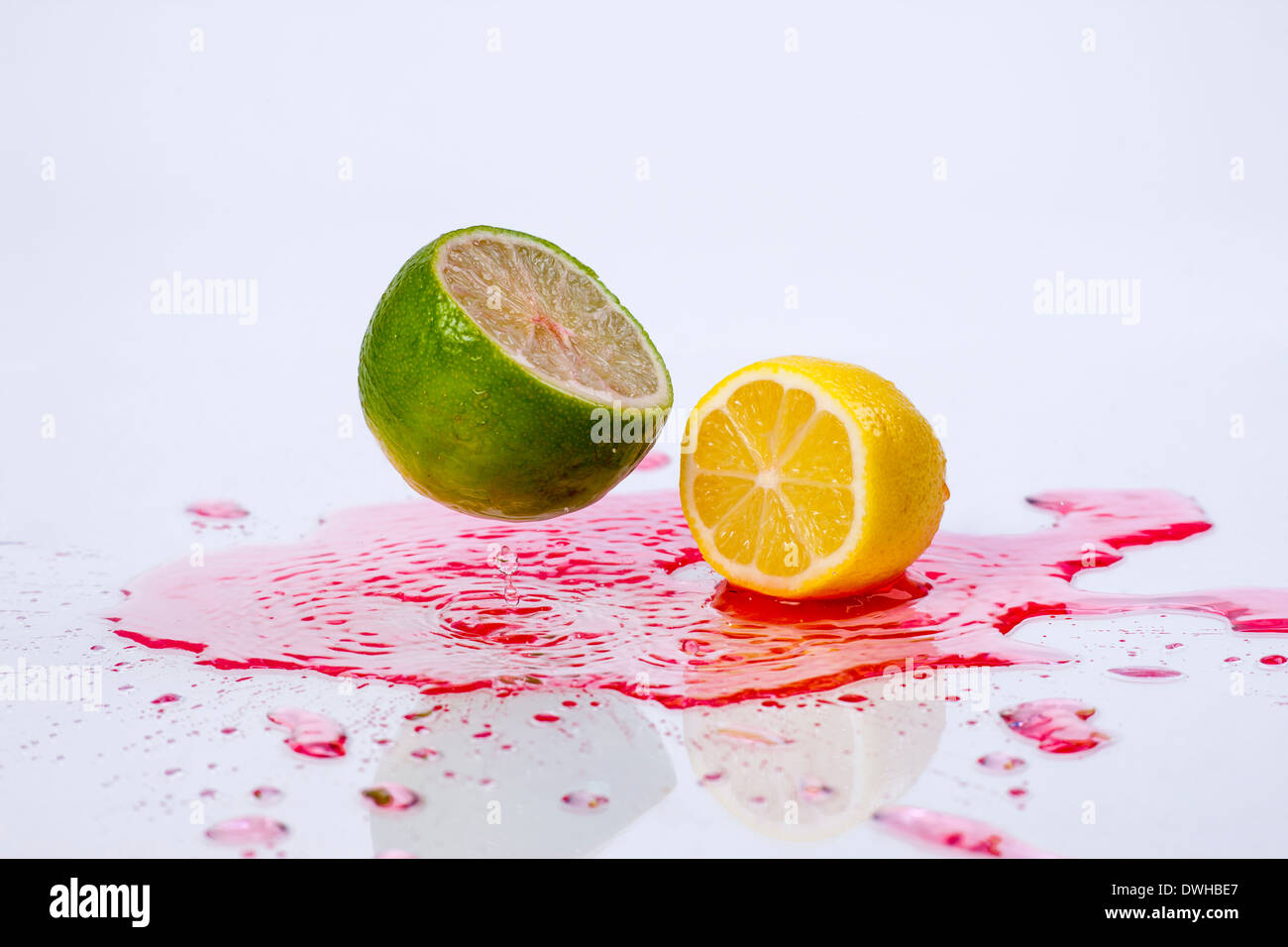 Dropping fruit into red liquid Stock Photo - Alamy