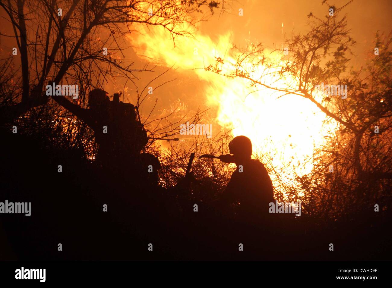 Kunming, China's Yunnan Province. 8th Mar, 2014. A firefighter douses a ...
