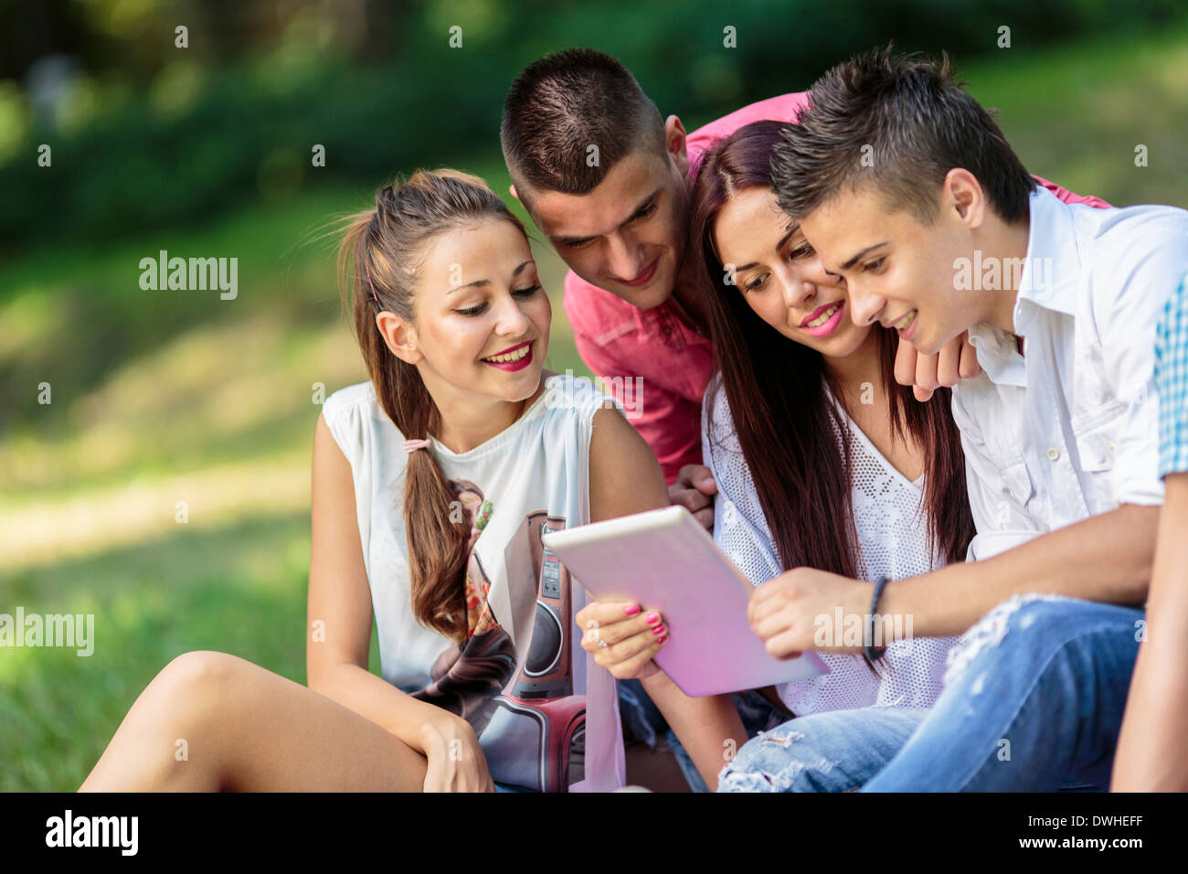 Teenagers in the park with tablet Stock Photo - Alamy