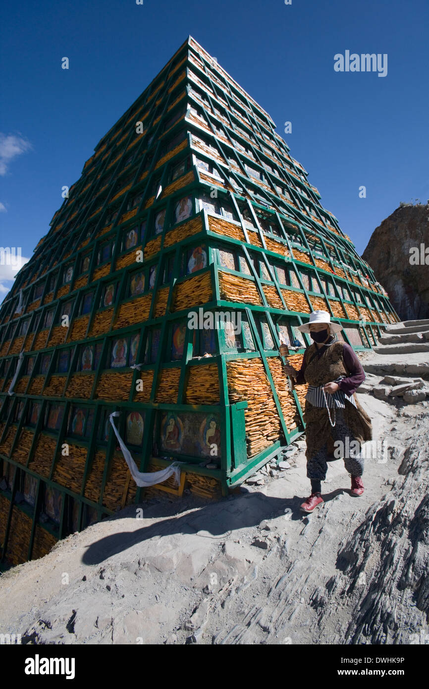 A Buddhist pilgrim passing a pyramid made of prayer scrolls at the ...