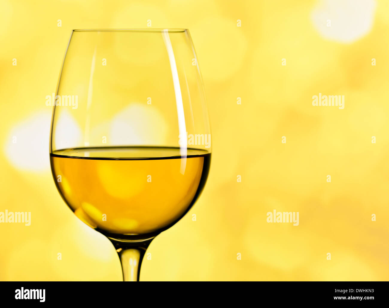 glass with white wine on yellow background Stock Photo - Alamy
