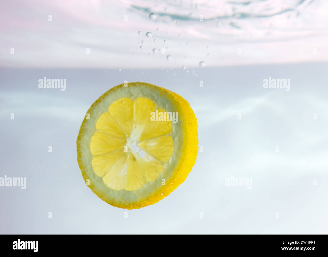 Sliced lemon falling through the water against a white background Stock ...