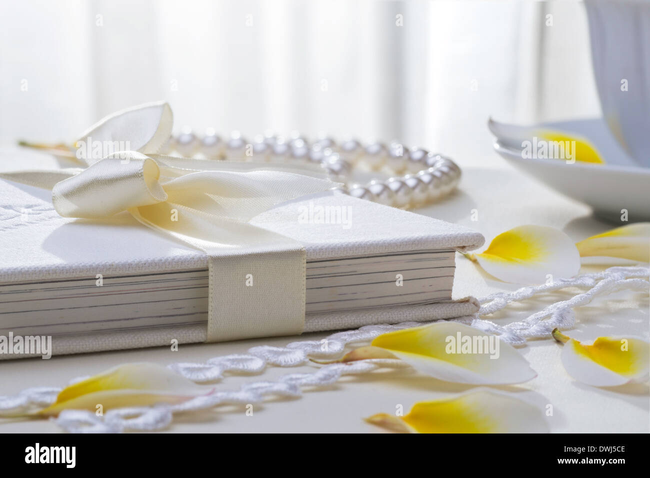 a white diary with a bow of creamy ribbon Stock Photo - Alamy