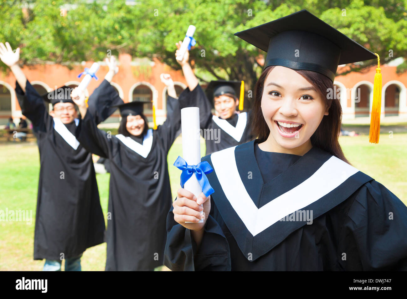 happy college graduate holding a diploma with friends at campus Stock ...