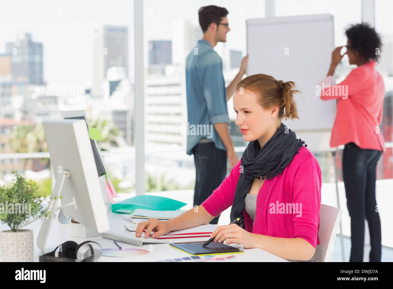 Female artist using graphic tablet with colleagues at office Stock ...
