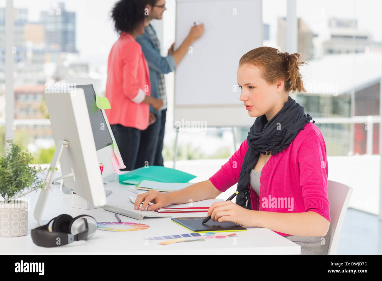 Female artist using graphic tablet with colleagues at office Stock ...