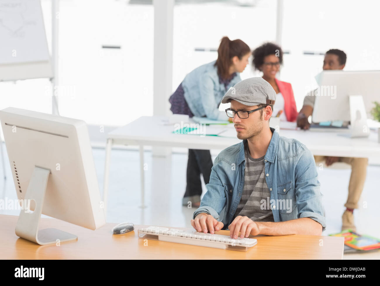 Male artist using computer with colleagues in at office Stock Photo - Alamy