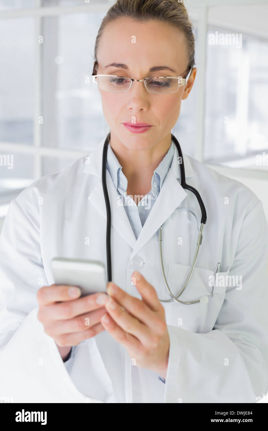 Female doctor reading text message in hospital Stock Photo - Alamy