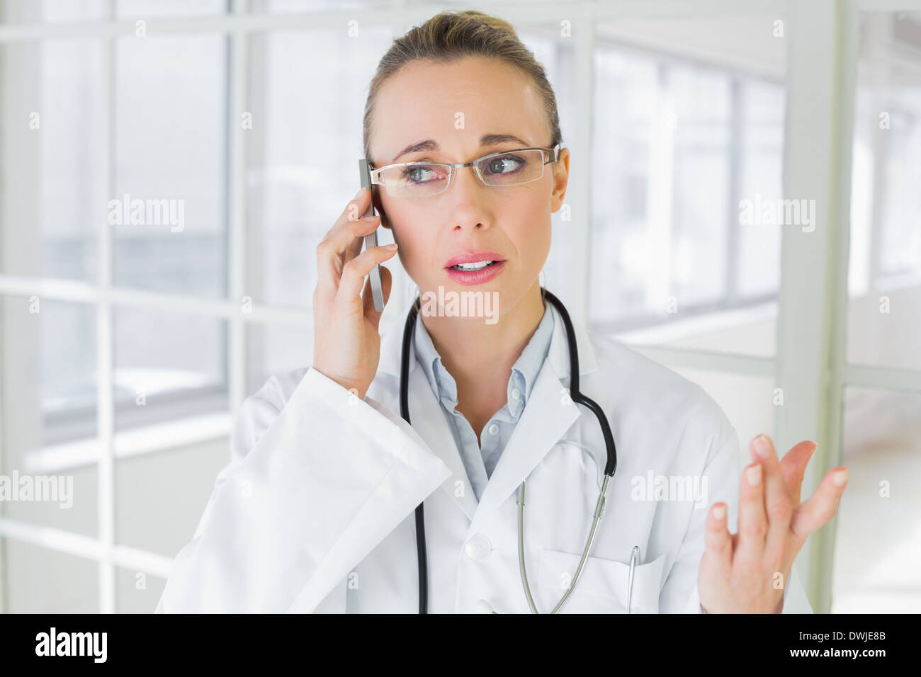 Beautiful female doctor using mobile phone Stock Photo - Alamy