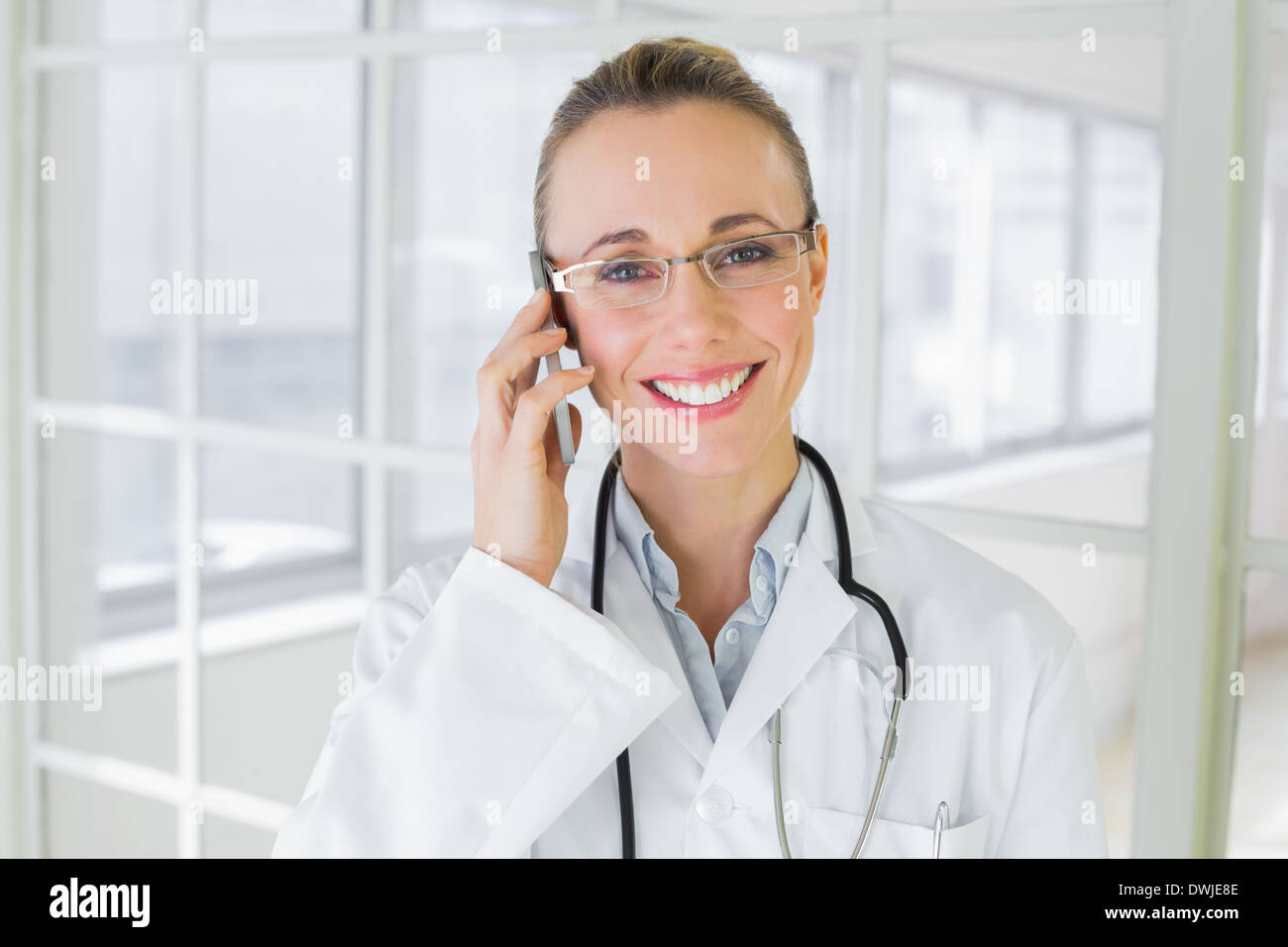 Beautiful female doctor using mobile phone Stock Photo - Alamy