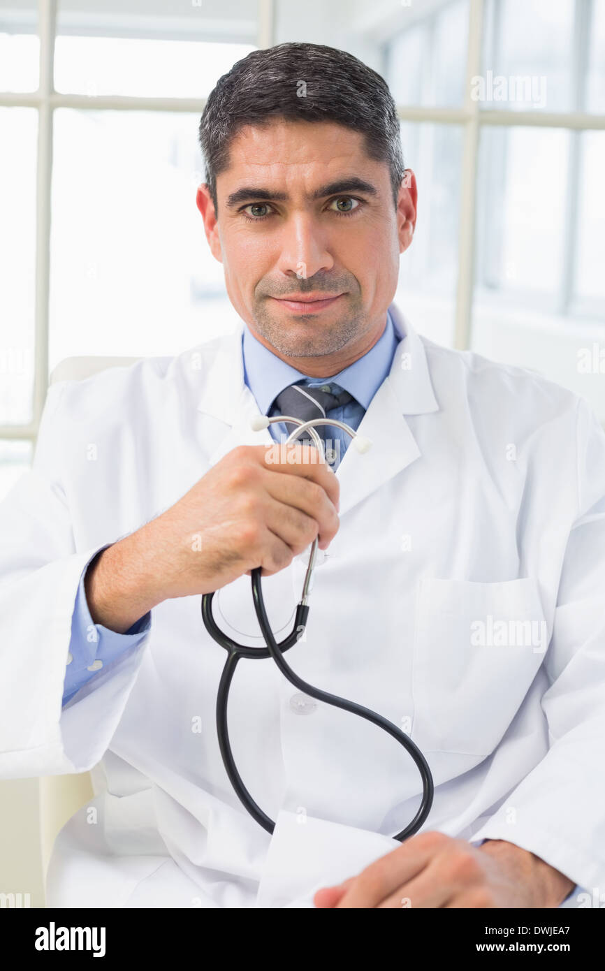 Serious male doctor holding stethoscope Stock Photo - Alamy