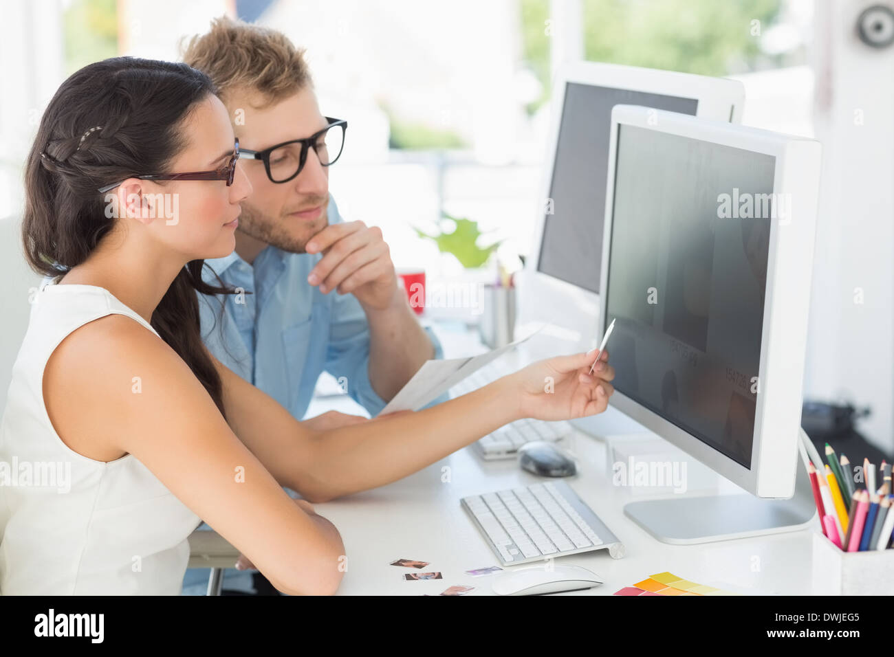 Creative partners working on computer at their desk Stock Photo - Alamy
