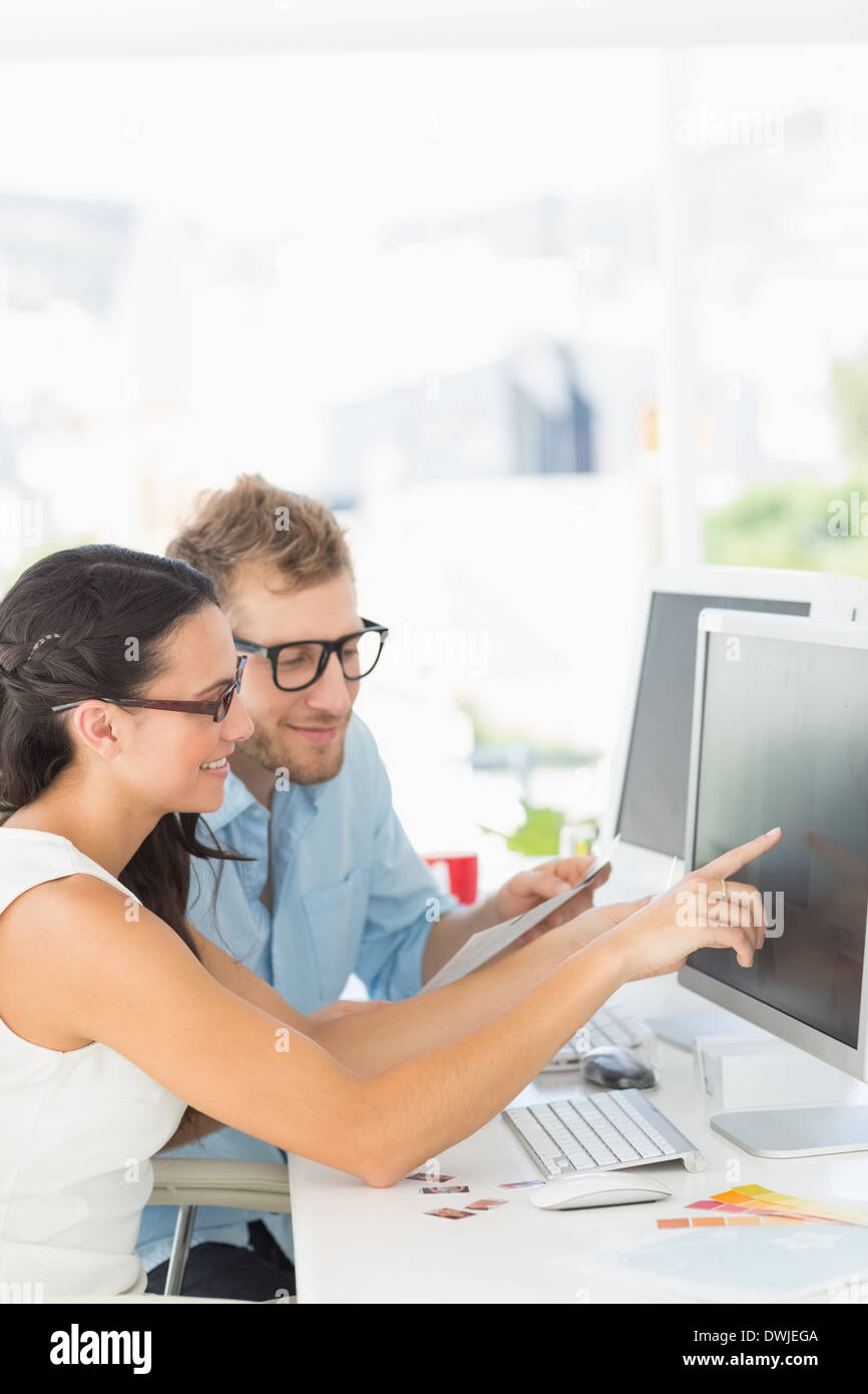 Creative partners working together on computer at their desk Stock ...