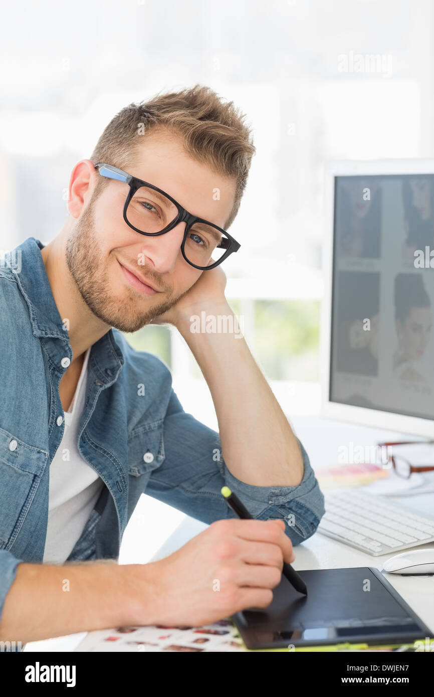 Handsome designer working with graphics tablet smiling at camera Stock ...