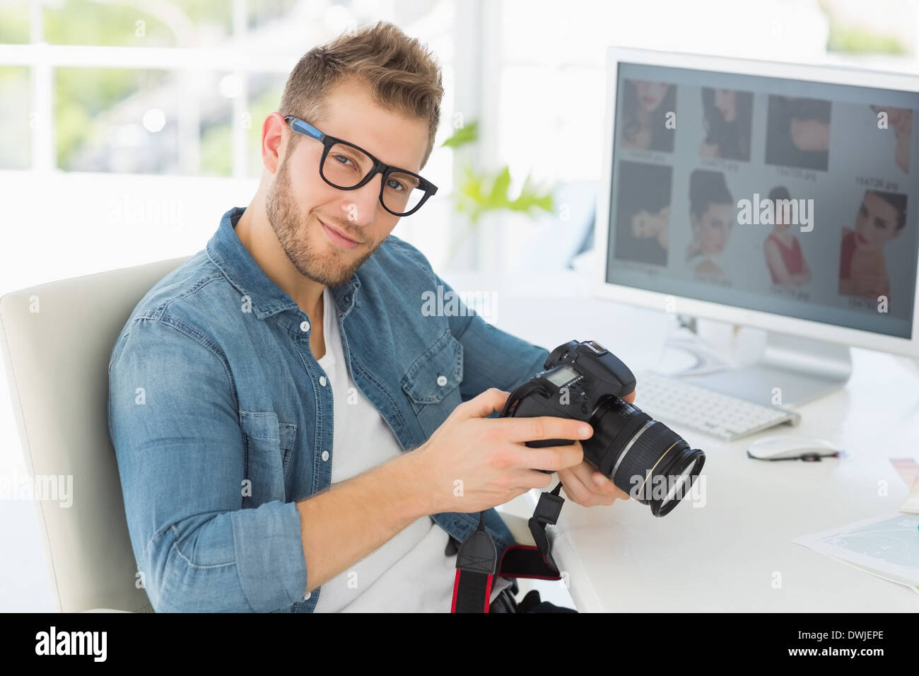 Handsome photographer holding his camera smiling at camera Stock Photo ...